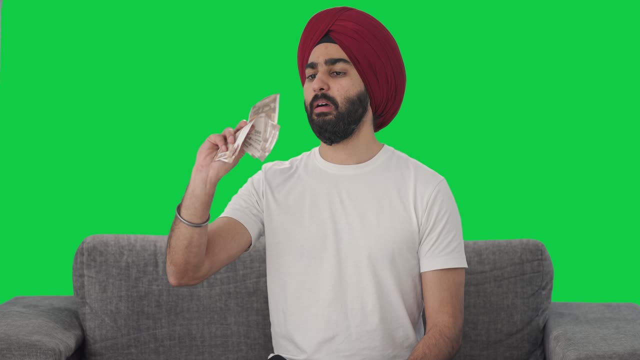 Premium stock video - Sikh indian man counting money green screen