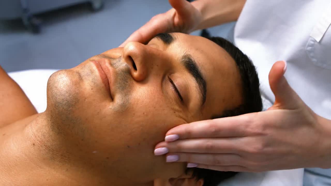 Premium stock video - Doctor applying cream on male patient face