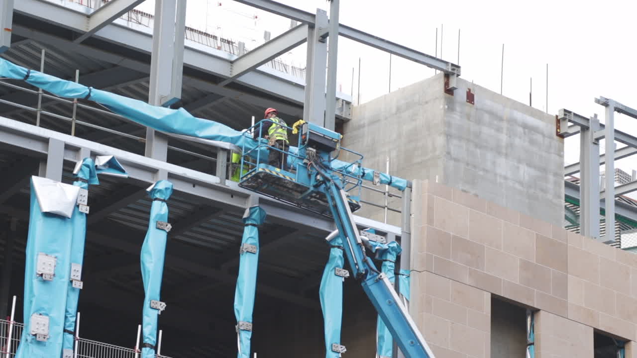 Premium stock video - Construction worker standing on the platform of ...