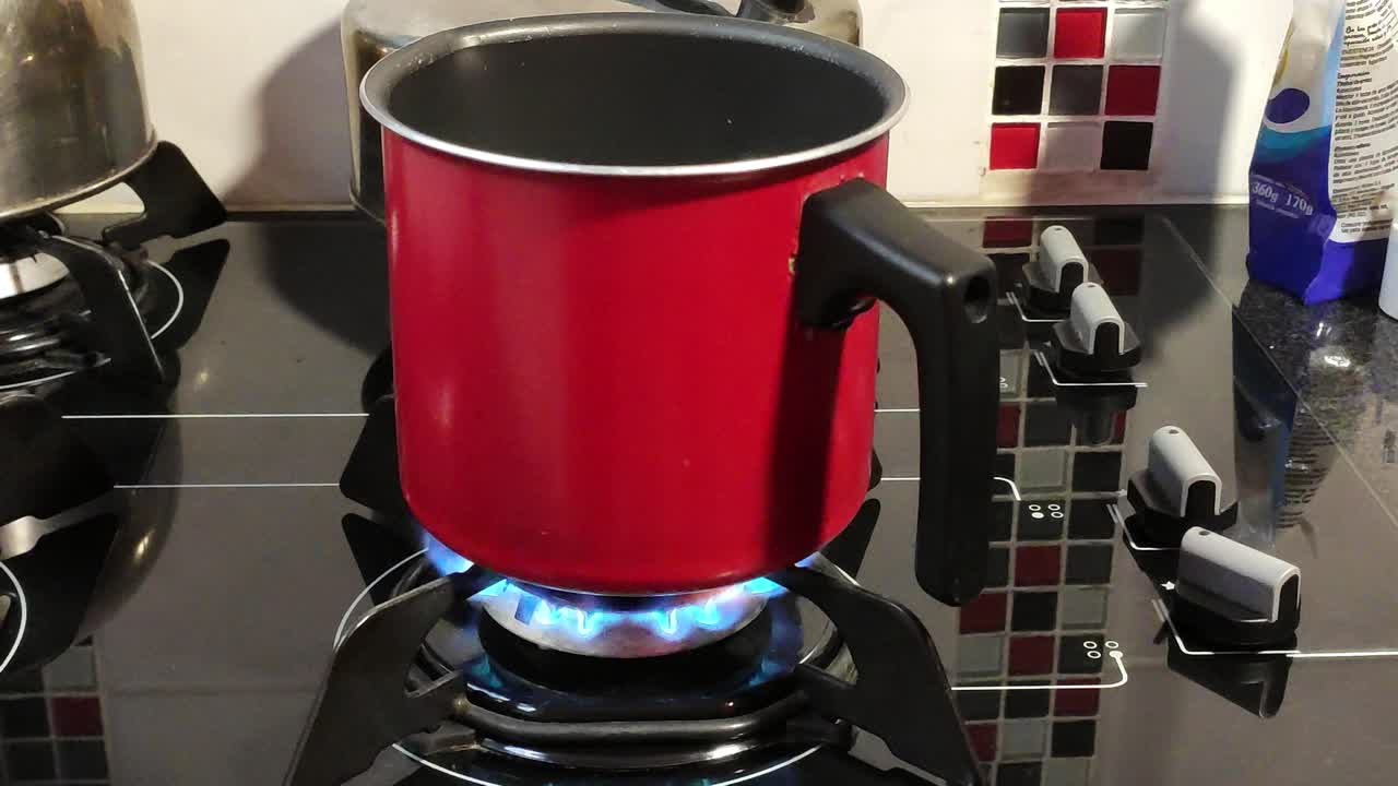 Red jar, pitcher in the hob warming up kitchen Premium Stock Video Footage